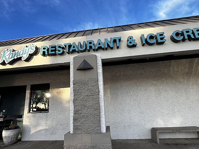 The iconic blue signage of Randy's Restaurant & Ice Cream stands out against Scottsdale's clear sky, beckoning hungry travelers like a desert oasis for comfort food enthusiasts.