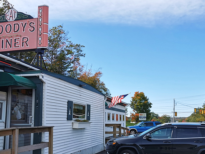 American flags and autumn foliage frame this roadside classic, where generations have pulled in for a taste of authentic Maine hospitality.