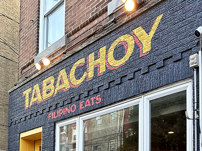 Look up! That bold yellow "TABACHOY" sign against textured navy blue is like a culinary bat signal for anyone seeking authentic Filipino eats in Philadelphia.