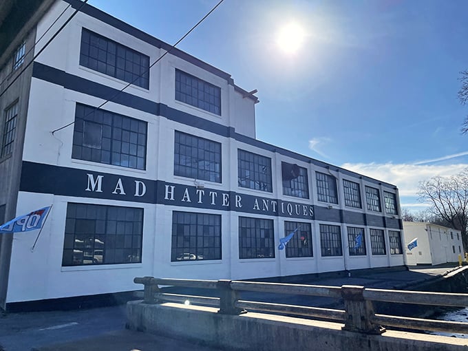 The imposing white facade of Mad Hatter Antique Mall stands like a time capsule waiting to be opened, promising treasures within its walls.