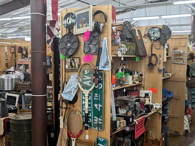 A treasure hunter's paradise awaits! Vintage tennis rackets hang alongside cast iron cookware in this wonderland of nostalgia and practical finds.
