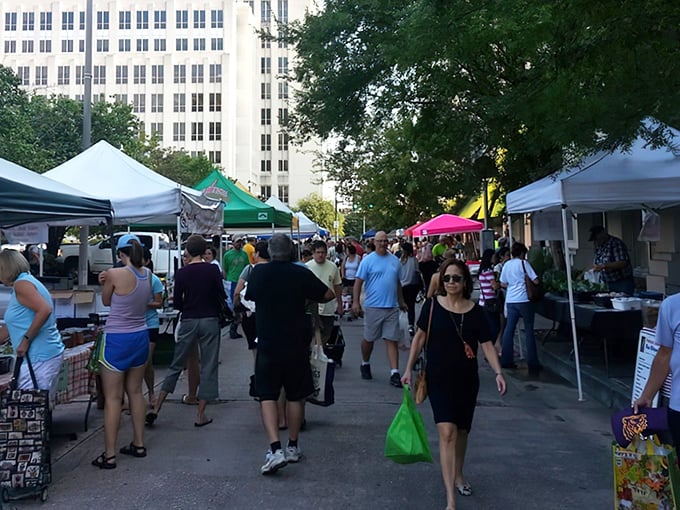 A bird's-eye view of market day magic! White tents create a patchwork quilt of local bounty against Baton Rouge's downtown skyline.