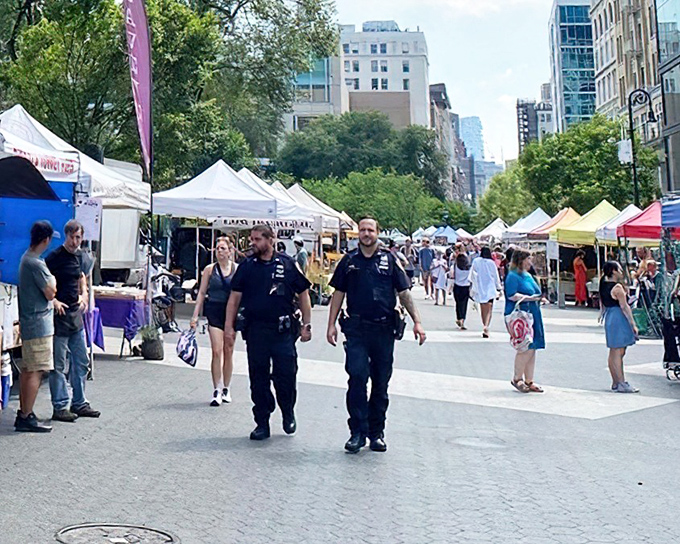 Police officers stroll through this urban food paradise where law and order meets lettuce and oranges.