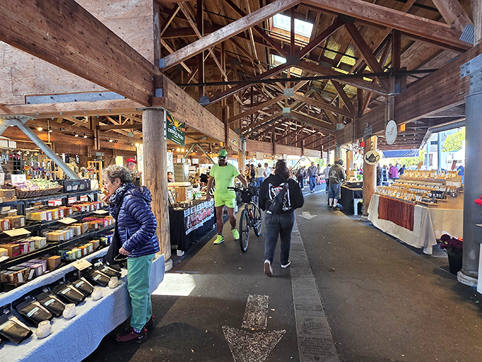 The timber-framed wonderland where shopping feels like a treasure hunt through Pacific Northwest bounty. Sunlight streams through rafters onto displays of local delights.