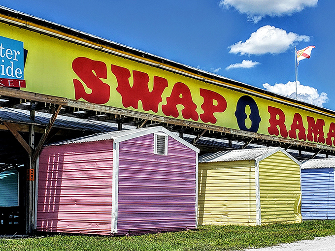 The iconic Swap-O-Rama sign stands like a technicolor beacon against Florida's blue sky, promising treasures beneath those candy-colored vendor sheds.