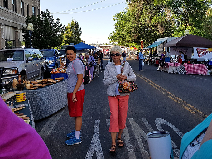 Market-goers weave between colorful tents like bees in a garden, each stall offering its own unique flavor of Montana craftsmanship.