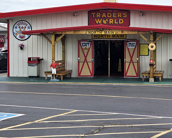 The iconic red barn doors of Traders World's North Main entrance stand as portals to bargain paradise, complete with a jockey statue standing guard.