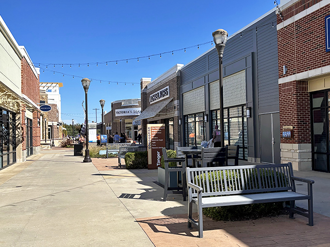 Wide walkways and inviting storefronts create the perfect backdrop for a day of bargain hunting. Blue skies and string lights add a touch of magic to the experience.