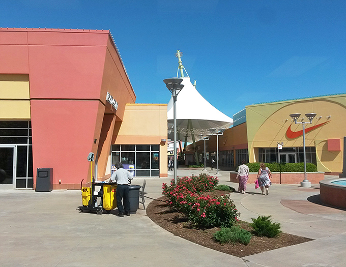 Colorful storefronts bask in Oklahoma sunshine, where shopping dreams and discount realities meet under those distinctive white canopies.