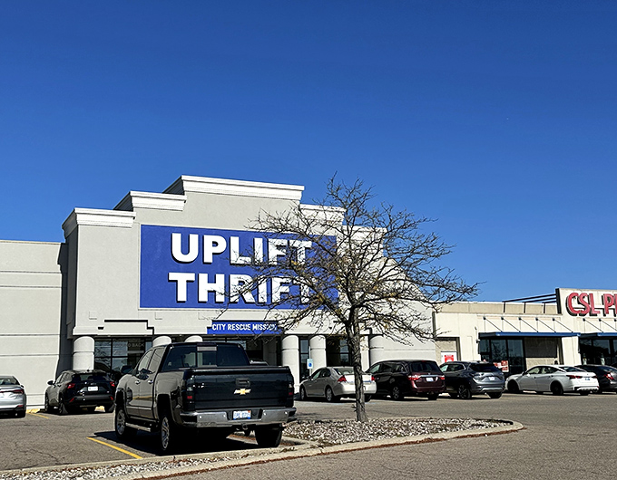 The bold blue sign of Uplift Thrift stands out like a beacon for bargain hunters, promising treasures waiting to be discovered inside.