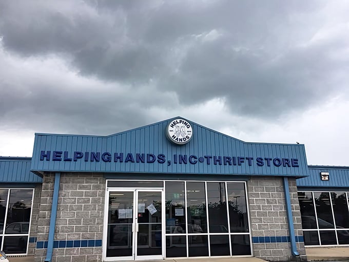 Under stormy skies, the bright blue facade of Helping Hands stands as a beacon for bargain hunters.