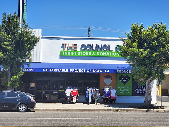 The blue awning beckons like a portal to bargain heaven. The Council Shop's storefront promises treasures within, while clothing racks offer a sneak preview.