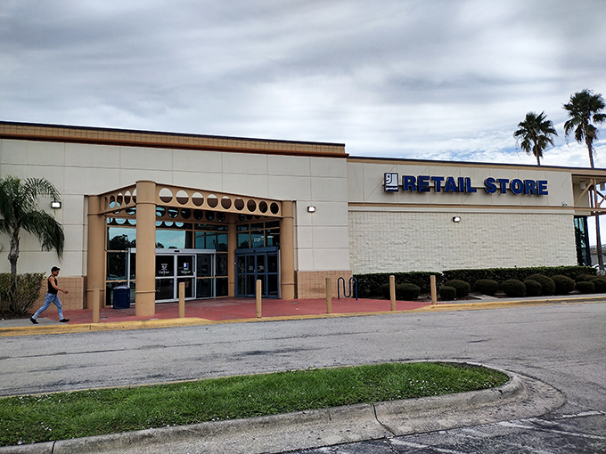 The unassuming exterior of Goodwill on Orange Blossom Trail hides a treasure trove within. Florida's palm trees stand guard over bargain paradise.