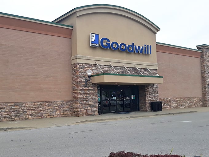 The blue Goodwill sign beckons like a lighthouse to bargain hunters. This Nicholasville storefront holds treasures waiting to be discovered inside its unassuming brick exterior.