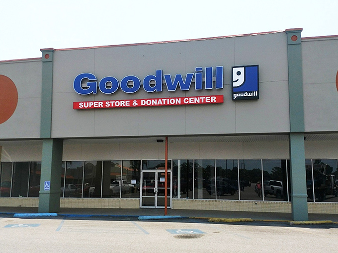 The blue Goodwill sign beckons like a lighthouse for bargain hunters, promising treasures waiting to be discovered inside.