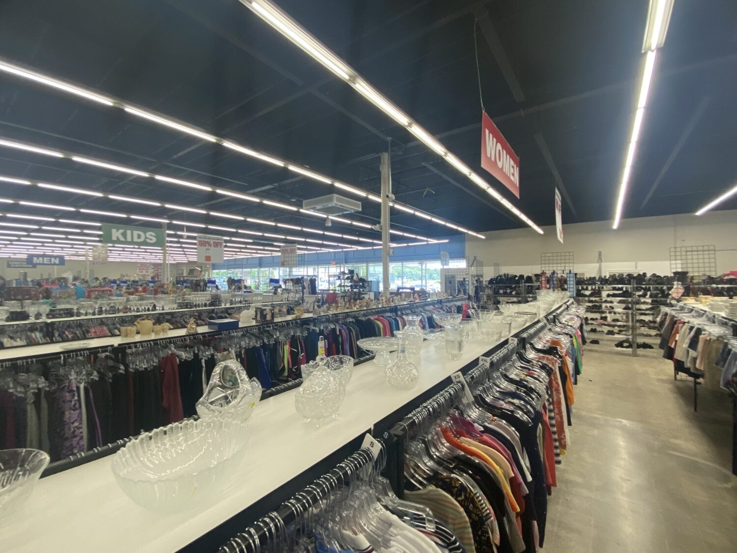 A shopper's paradise unfolds with clearly marked departments, where clothing racks stretch toward the horizon like a budget-friendly retail universe.