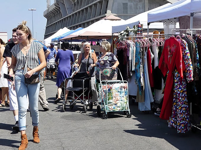Vintage fashion hunters paradise! Colorful racks of clothing from bygone eras await shoppers with rolling carts ready to haul away their nostalgic treasures.