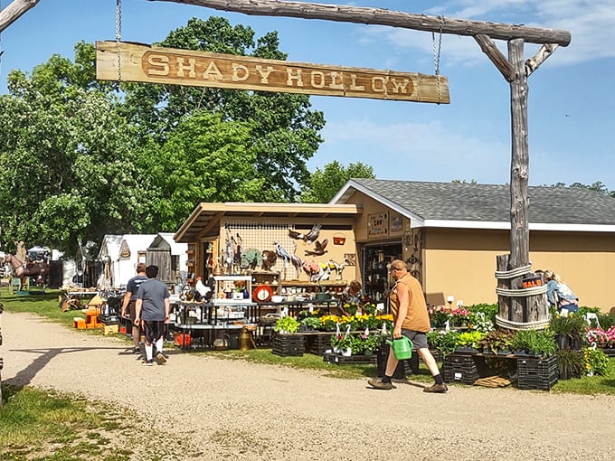 The rustic wooden sign welcomes bargain seekers like an old friend, promising adventures down gravel paths where forgotten treasures await new homes.