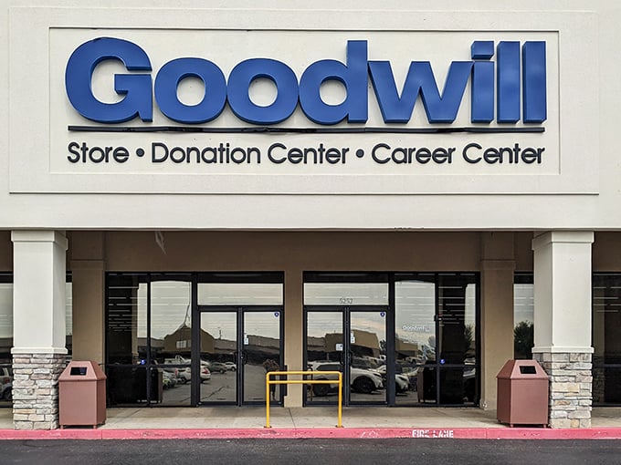 The blue Goodwill sign beckons like a lighthouse to bargain hunters navigating the sea of retail options in Springdale.