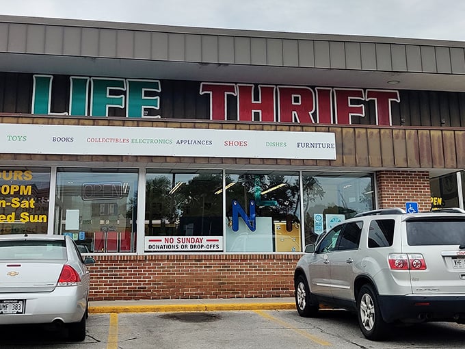 The bold red and teal signage of New Life Thrift Store beckons bargain hunters like a lighthouse for the frugally fashionable.