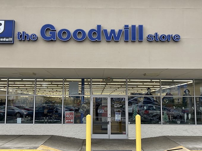 The blue Goodwill sign beckons like a lighthouse for bargain hunters. Behind these unassuming doors, fashion treasures await discovery.