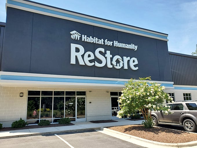 The sleek exterior of Clayton's Habitat ReStore beckons like a blue-trimmed treasure chest waiting to be opened. No ordinary thrift store facade here!