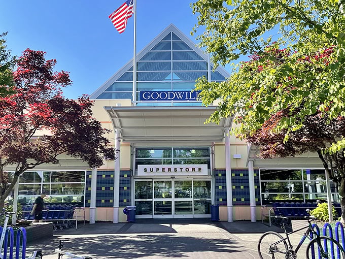The grand entrance to treasure-hunting paradise! Goodwill's distinctive triangular roofline and blue accents welcome bargain seekers like a retail Narnia for the budget-conscious.