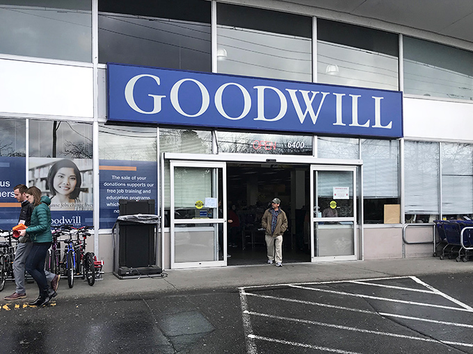 The iconic blue Goodwill sign beckons bargain hunters like a retail lighthouse. Seattle's notorious drizzle can't dampen the thrill of what treasures await inside.