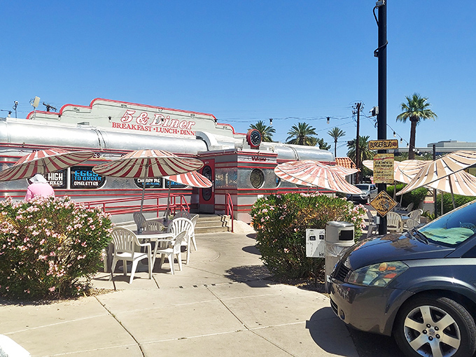 The gleaming chrome exterior of 5 & Diner shines like a beacon of nostalgia, its red and white stripes promising a time-traveling culinary adventure in the Arizona sun.