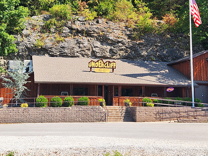 The iconic Undercliff sign glows warmly against the rugged cliff backdrop, welcoming hungry travelers to this geological dining wonder.