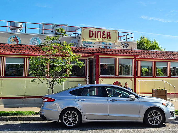 The gleaming vintage dining car beckons like a time machine disguised as a restaurant. Classic cream and burgundy exterior says "come in, we've been expecting you."