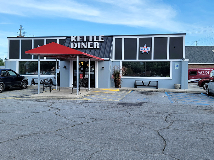 The unassuming exterior of The Kettle Diner, where culinary magic happens behind that red awning. Food paradise doesn't always wear fancy clothes.