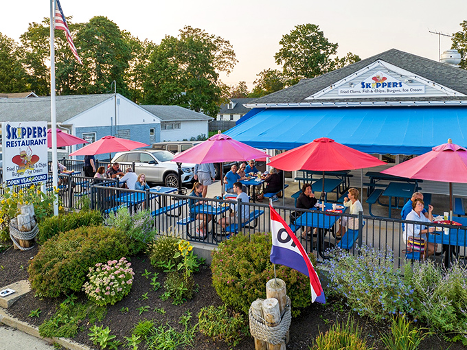Skippers' cheerful blue awnings and vibrant red umbrellas create the perfect coastal vibe, where seafood dreams come true under Connecticut skies.