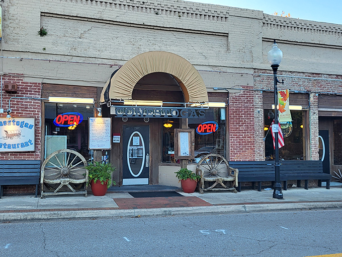 The historic facade of Conestogas Restaurant stands as a welcoming beacon on Alachua's Main Street, complete with wagon wheels that hint at the Western-themed delights waiting inside.