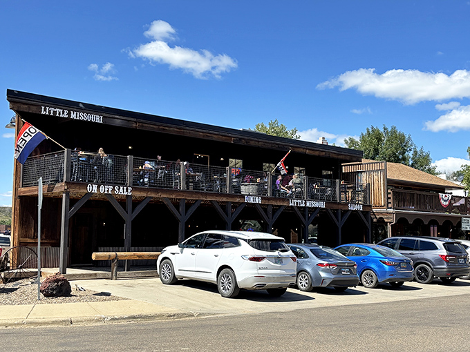 The Little Missouri Saloon stands proudly in Medora, its rustic wooden facade and balcony beckoning hungry travelers like a frontier oasis in the Badlands.