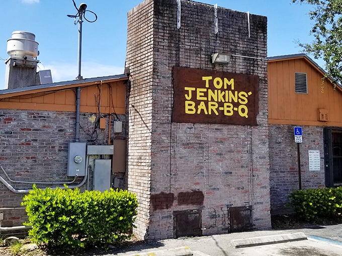 The brick fortress of flavor announces itself with no fanfare needed. That yellow sign is Florida's equivalent of a barbecue bat signal.