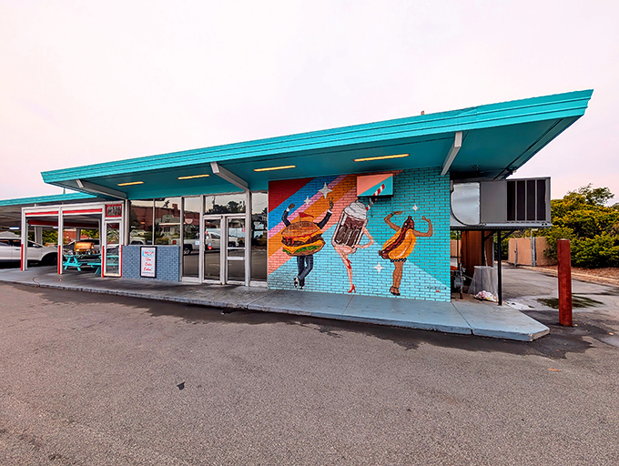 That iconic teal roof and dancing food mural welcome hungry visitors to Sno-Cap Drive-In's time-traveling culinary experience in North Augusta.