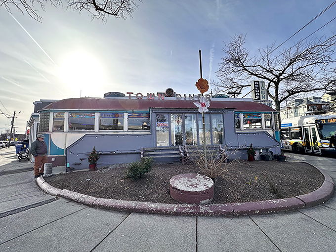 The classic stainless steel exterior of Deluxe Town Diner gleams in the sunlight, a chrome time capsule promising breakfast nirvana in Watertown.