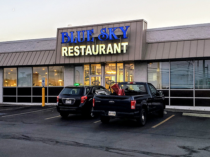 The iconic blue sign glows like a beacon at dusk, promising comfort food salvation for hungry travelers and locals alike.