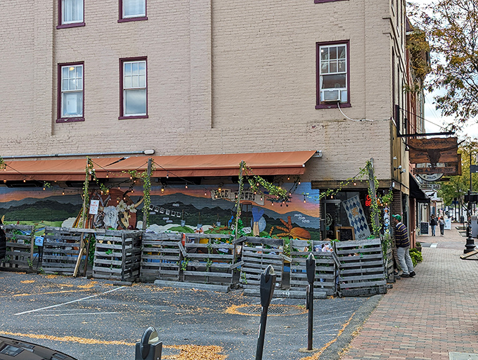 A rustic outdoor seating area where string lights and a whimsical burger mural transform parking spaces into prime dining real estate. Alfresco burger bliss!