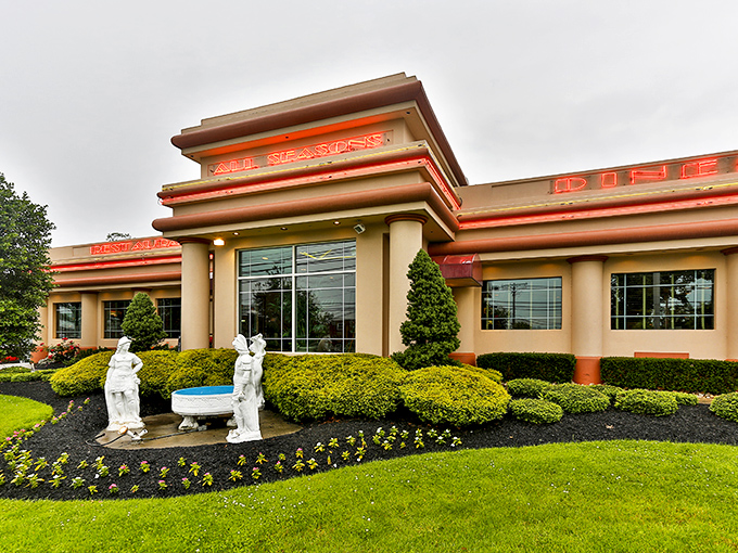 Garden statues welcome you with old-world charm, while the neon-lit sign glows like a beacon for breakfast enthusiasts seeking their morning fix.