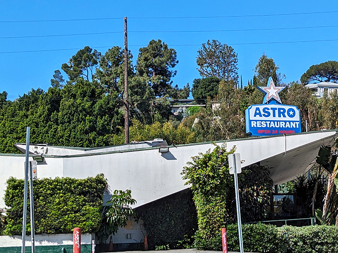 The iconic Googie architecture of Astro Restaurant stands proudly against the California sky, its star-topped sign beckoning hungry travelers like a mid-century lighthouse.