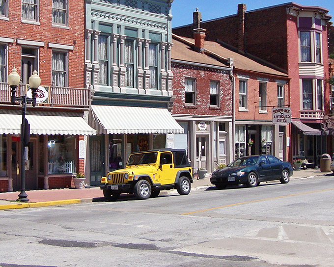 Downtown Hannibal's historic brick facades stand like a living museum, where modern yellow Jeeps park alongside 19th-century architectural treasures.