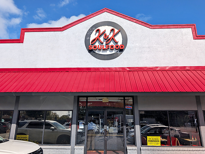 The iconic red-trimmed exterior of K&K Soul Food stands like a beacon of culinary promise against the Atlanta sky. Soul food salvation awaits inside.