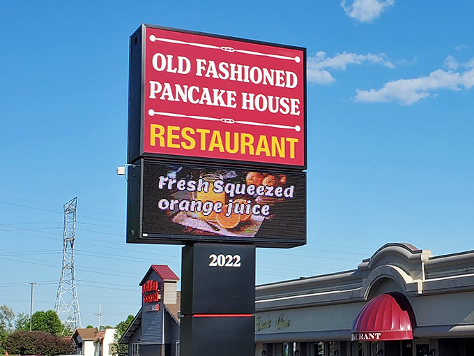 The iconic red sign beckons hungry travelers like a breakfast lighthouse guiding ships to syrupy shores.