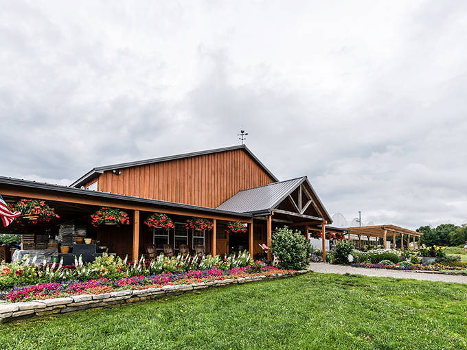 The welcoming barn-style market building surrounded by colorful flower beds sets the perfect tone for your farm adventure.