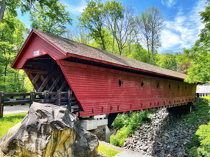 Like a crimson sentinel standing guard over the stream below, the Newfield Covered Bridge combines rustic charm with engineering ingenuity that's lasted generations.