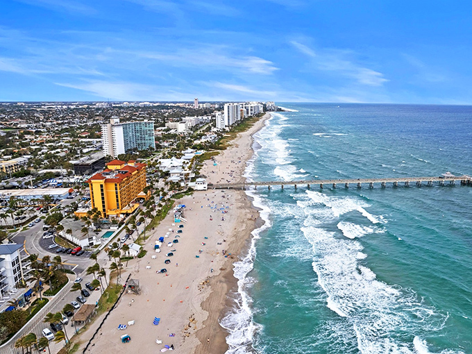 Aerial paradise where turquoise waves kiss golden shores. Deerfield Beach's iconic pier stretches into the Atlantic like nature's welcome mat to paradise.