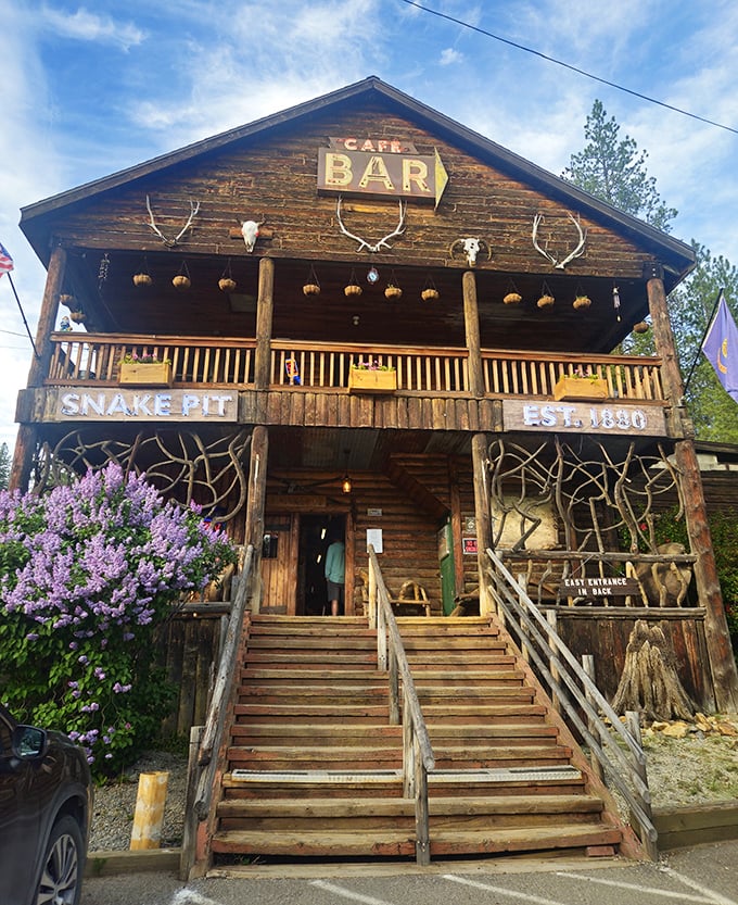 The Snake Pit's rustic log cabin exterior isn't just Instagram-worthy—it's a time portal to Idaho's wild frontier days, complete with antlers and blooming lilacs.