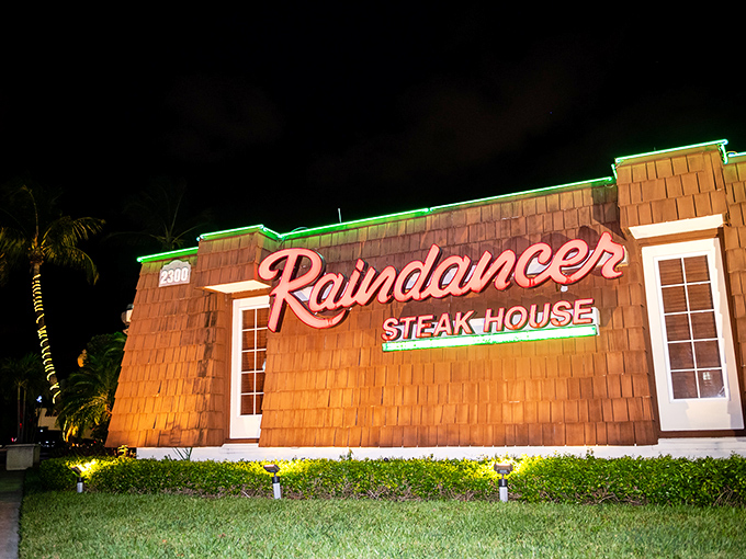 The neon glow of Raindancer Steakhouse beckons meat lovers like a carnivorous lighthouse in the West Palm Beach night.